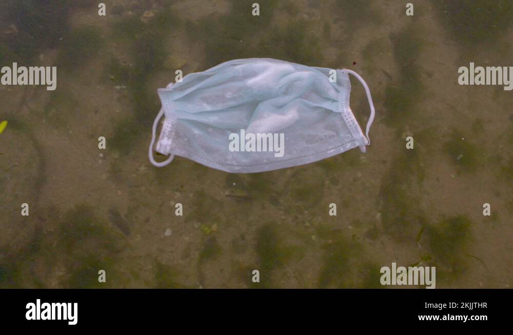 Slowmotion of garbage from used medical masks on sea water. Pollution ...