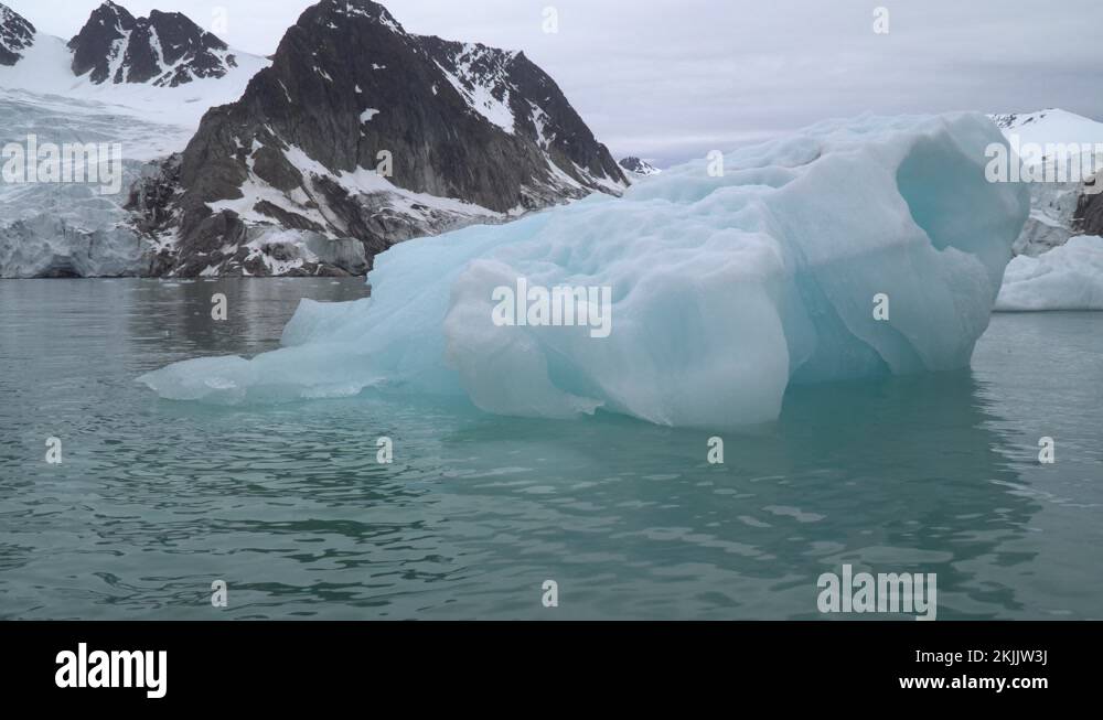 Arctic sailing among glaciers and floating ice blocks, in frozen sea ...