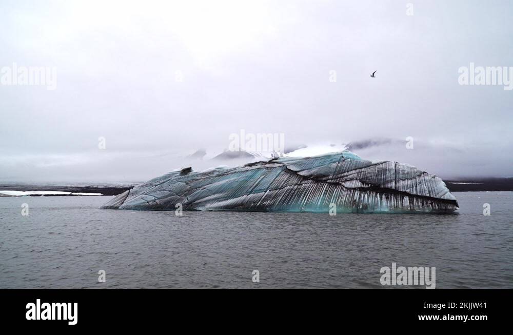 Arctic sailing among glaciers and floating ice blocks, in frozen sea ...