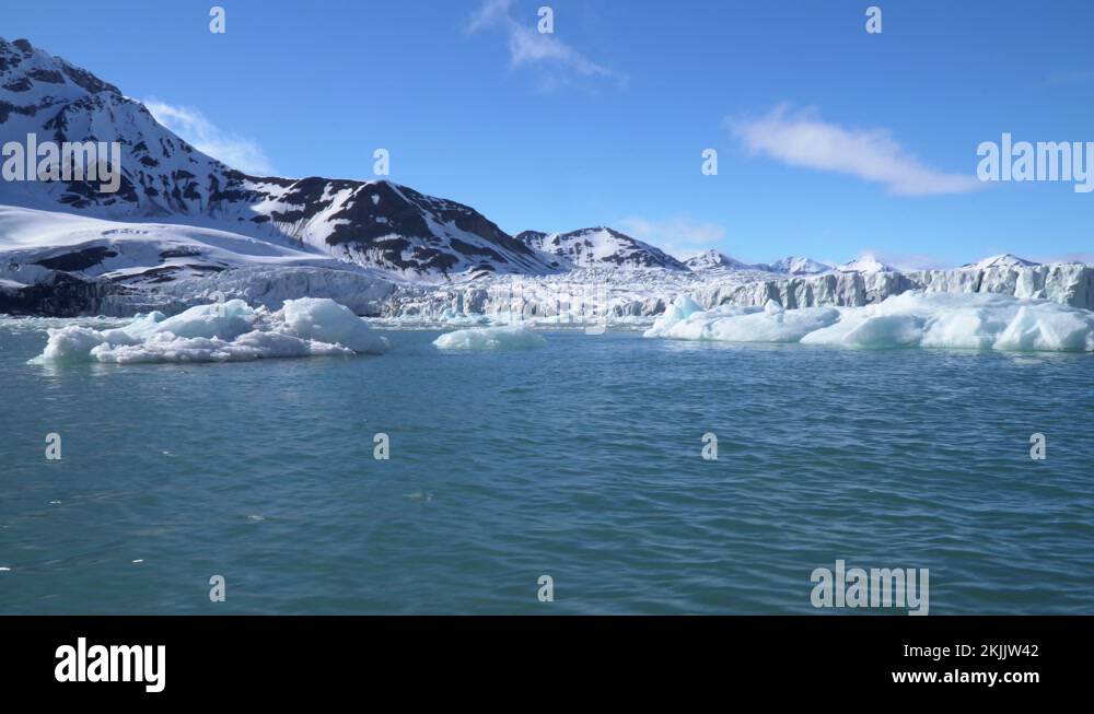 Arctic sailing among glaciers and floating ice blocks, in frozen sea ...