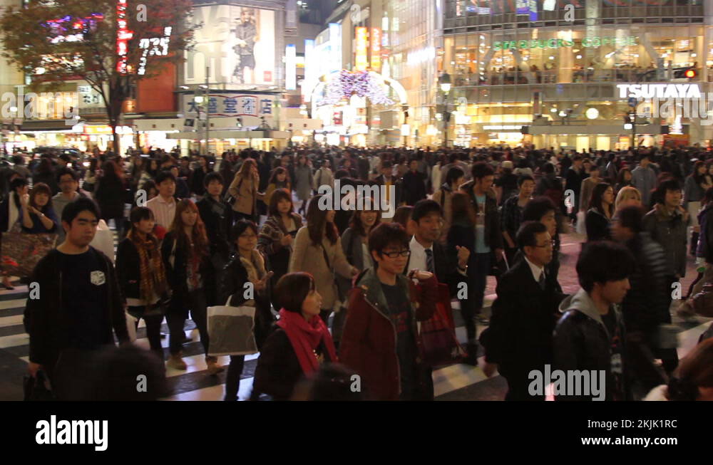 Crowds walk across a crossroads or scramblewalk in Tokyo's Shibuya ...