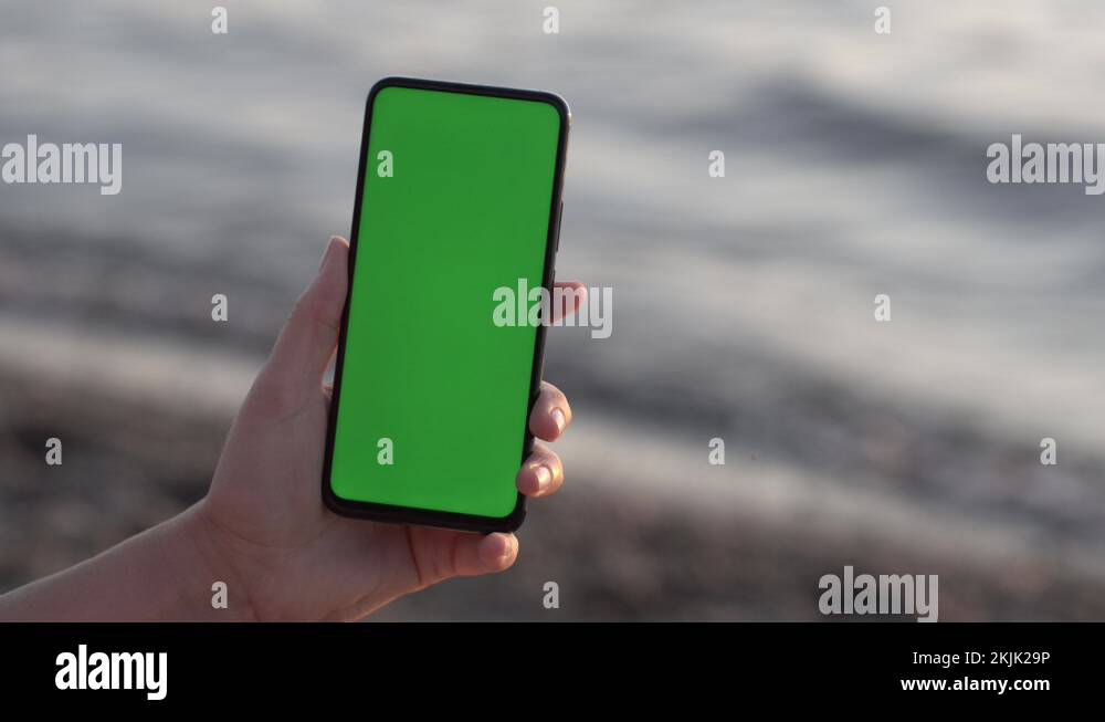 Handheld Camera: back view of brunette holding chroma key green screen ...