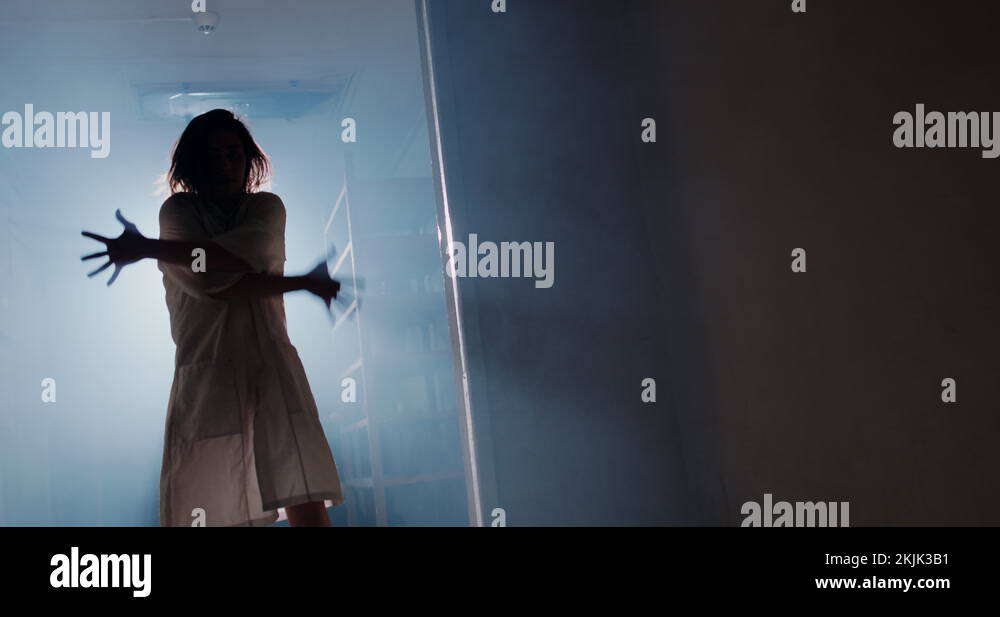 Scary girl in white straitjacket agonizing in exorcism. Creepy patient ...