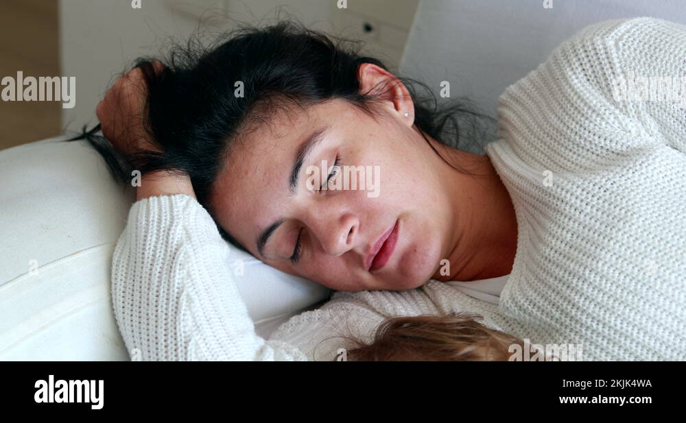 Mother sleeping lying in sofa with baby. Mom and infant asleep laid in ...