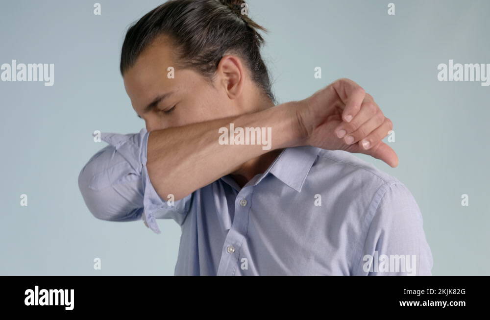 A male coughs in his elbow. The correct way of sneezing to stop the ...