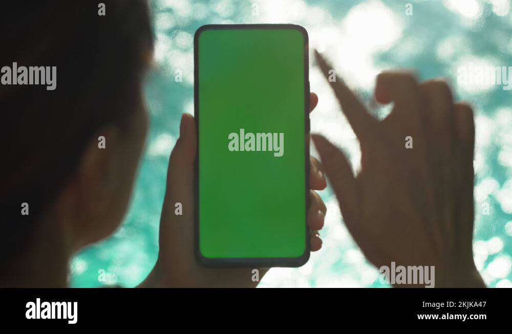 Handheld Camera: back view of brunette holding chroma key green screen ...