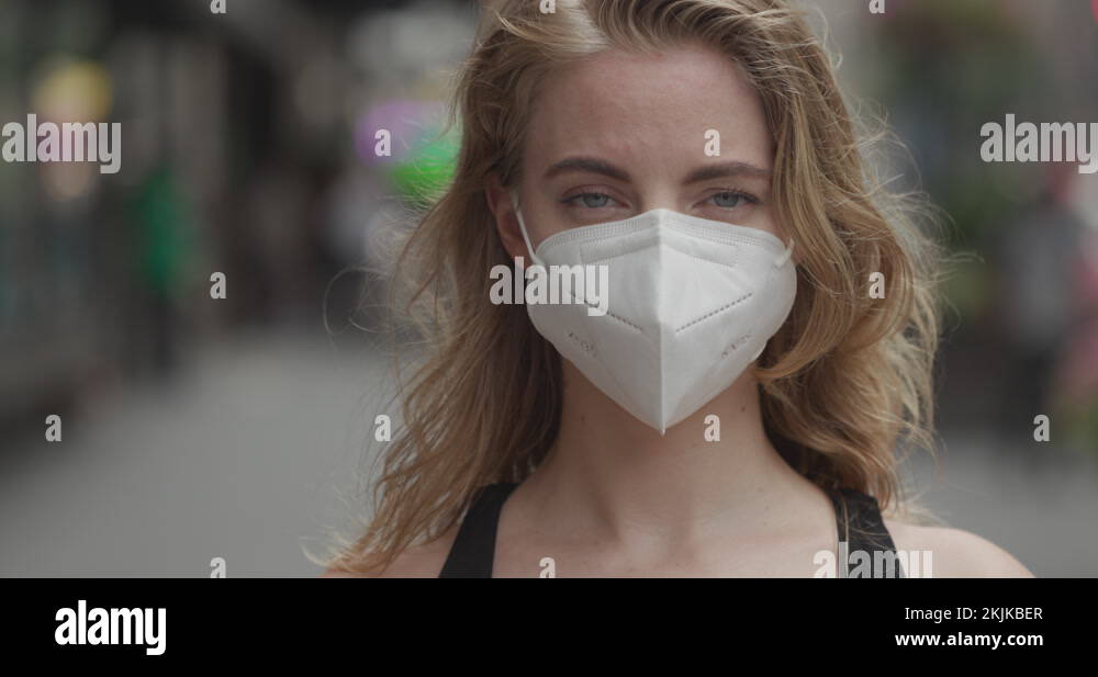 Young blond woman taking off a mask smiling happy coronavirus covid ...