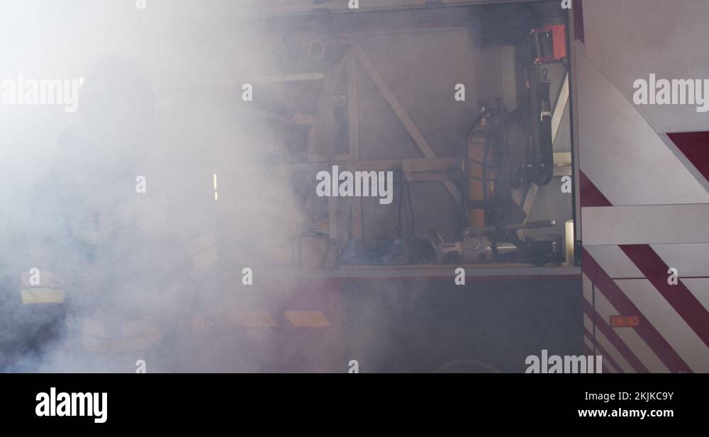 Middle plan of tired Caucasian young man fire fighter taking off helmet ...