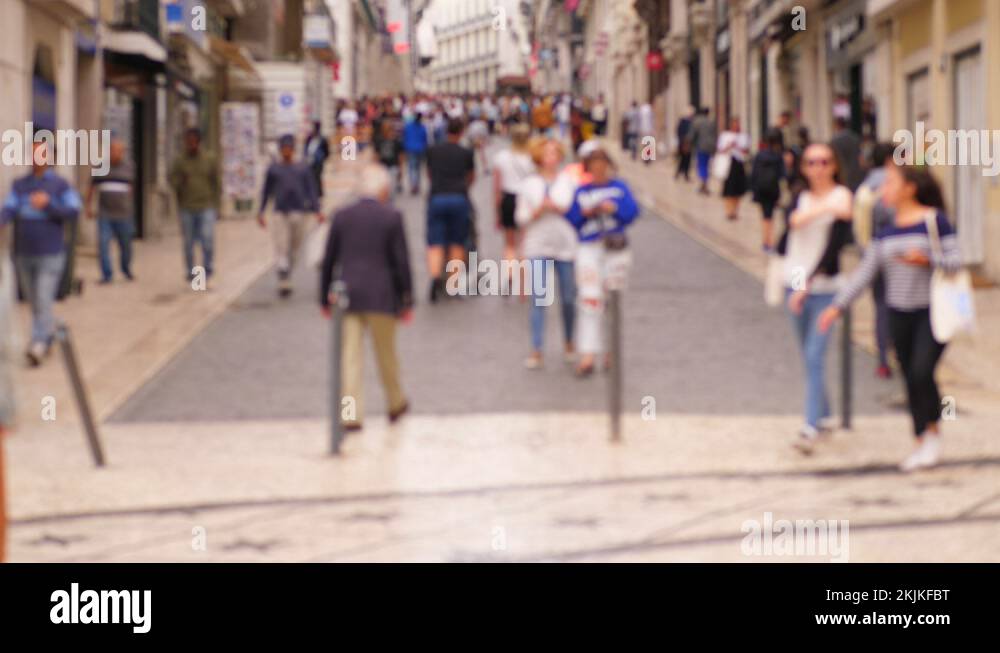 People stroll at bottom end of pedestrian street in downtown, blurred ...