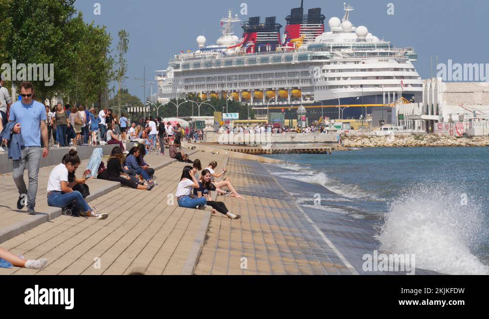 People sit at broad stairway of embankment, water splash on steps Stock ...