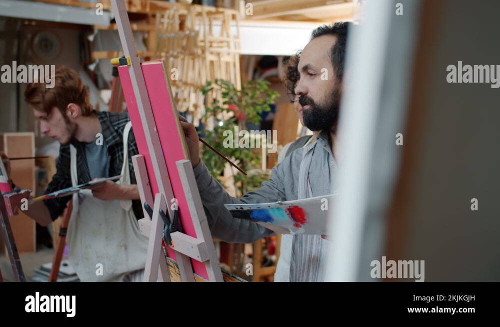 Experienced artist showing young lady how to paint pictures teaching in ...