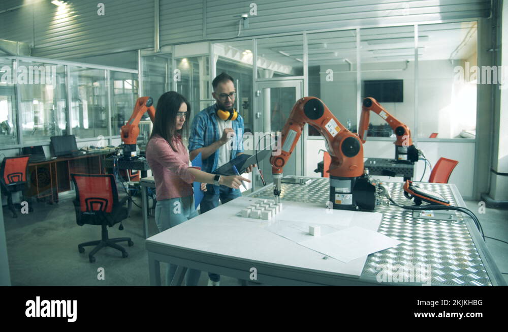 Workers check robotic arm in action. Innovation, hi-tech education ...