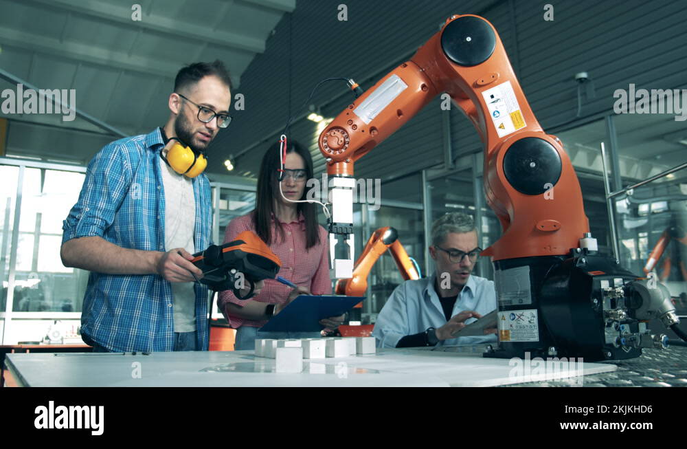 People control robotic arm with tablets. Innovation, hi-tech education ...