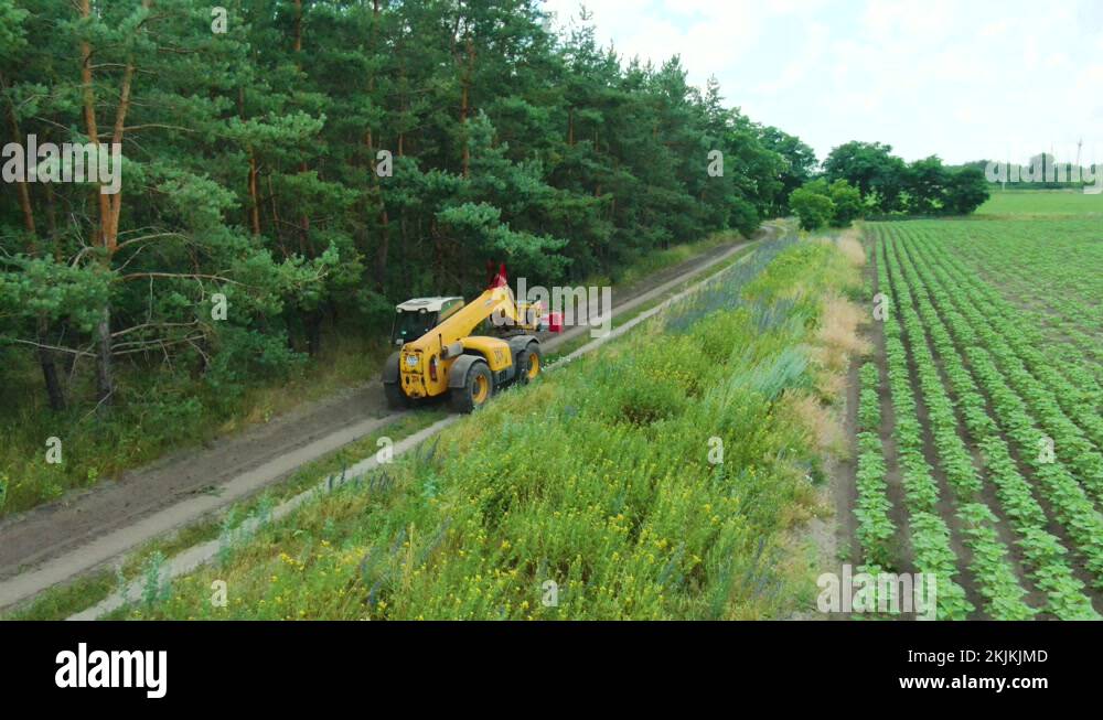 Big machine with a crane elevated is driving on a dusty road, woods, 4k ...