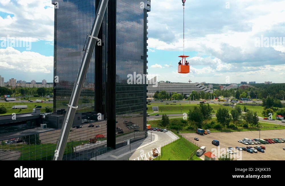 Two construction workers in the building cradle of a mobile crane ...