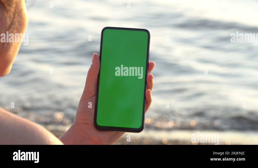 Handheld Camera: back view of brunette holding chroma key green screen ...