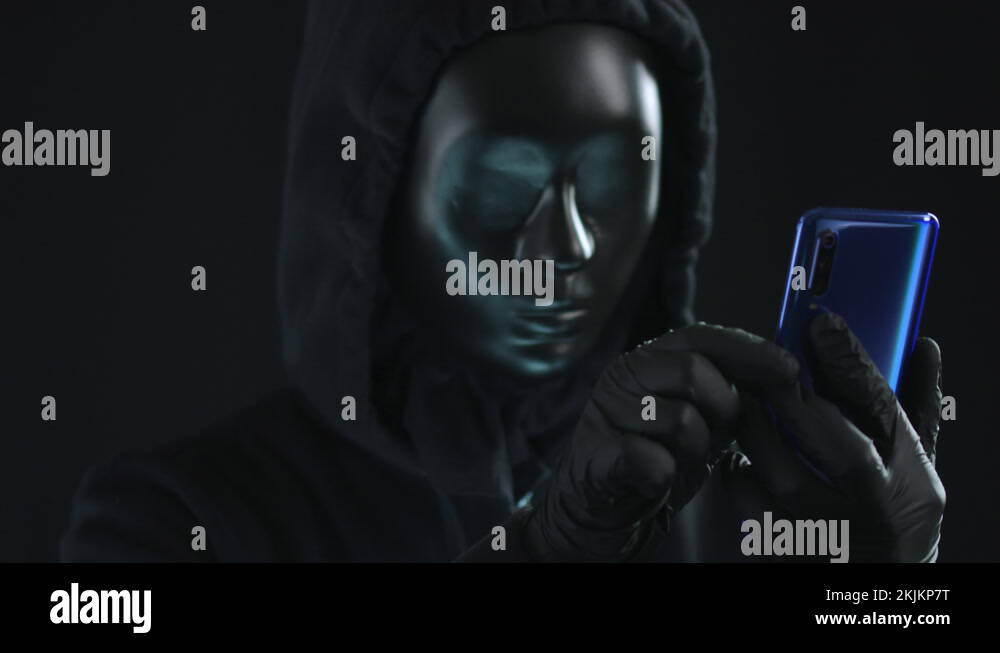 Hacker wearing black mask pulls ERROR tab from a smartphone. Hacking ...