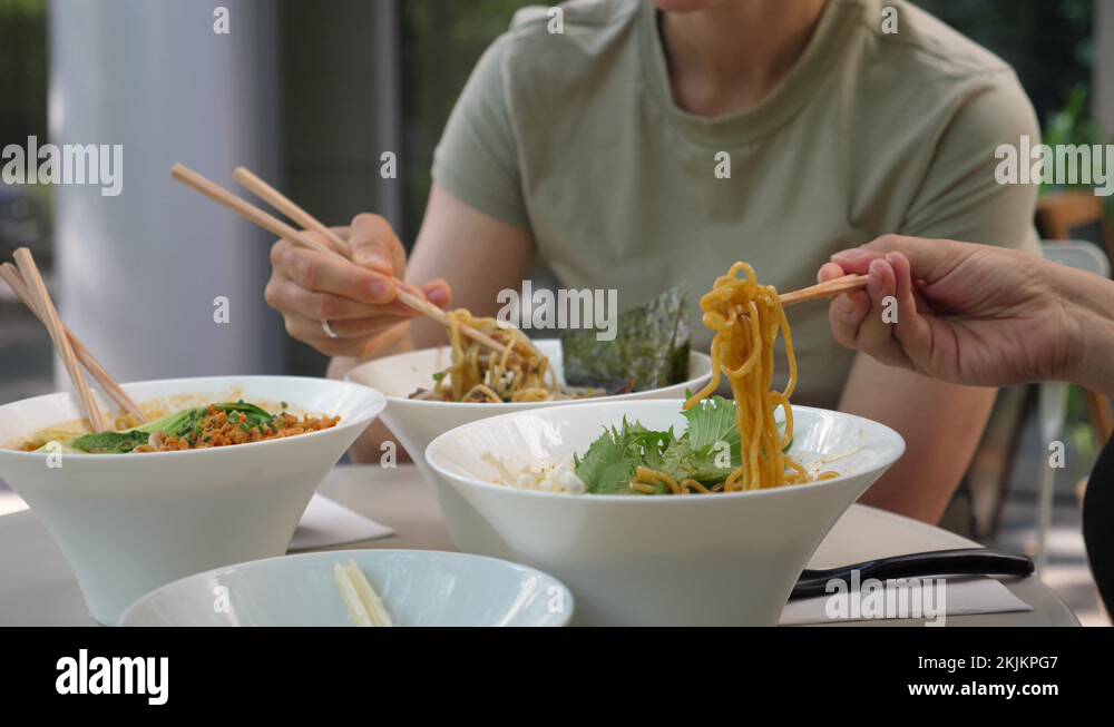 Two girls eating their delicious traditional Japanese ramen soups ...