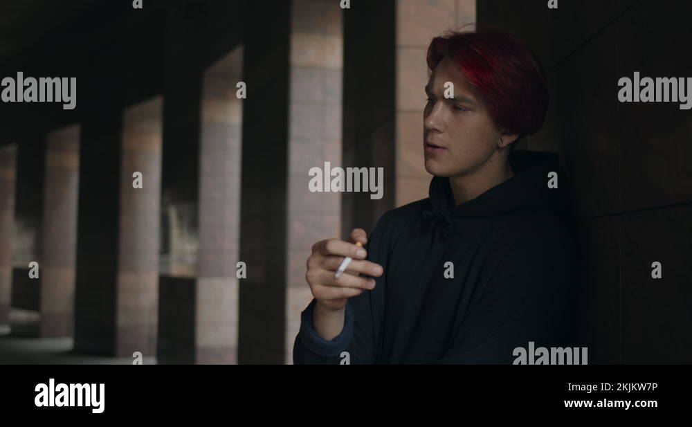 Crop view of millennial guy in depression smoking cigarette and ...
