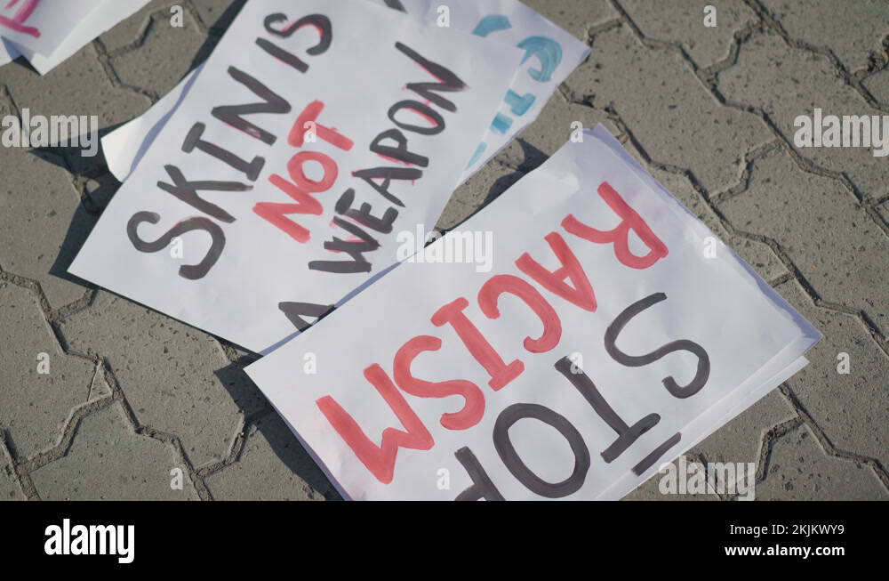 Banners against racism lying on paving stones. Posters with slogans for ...
