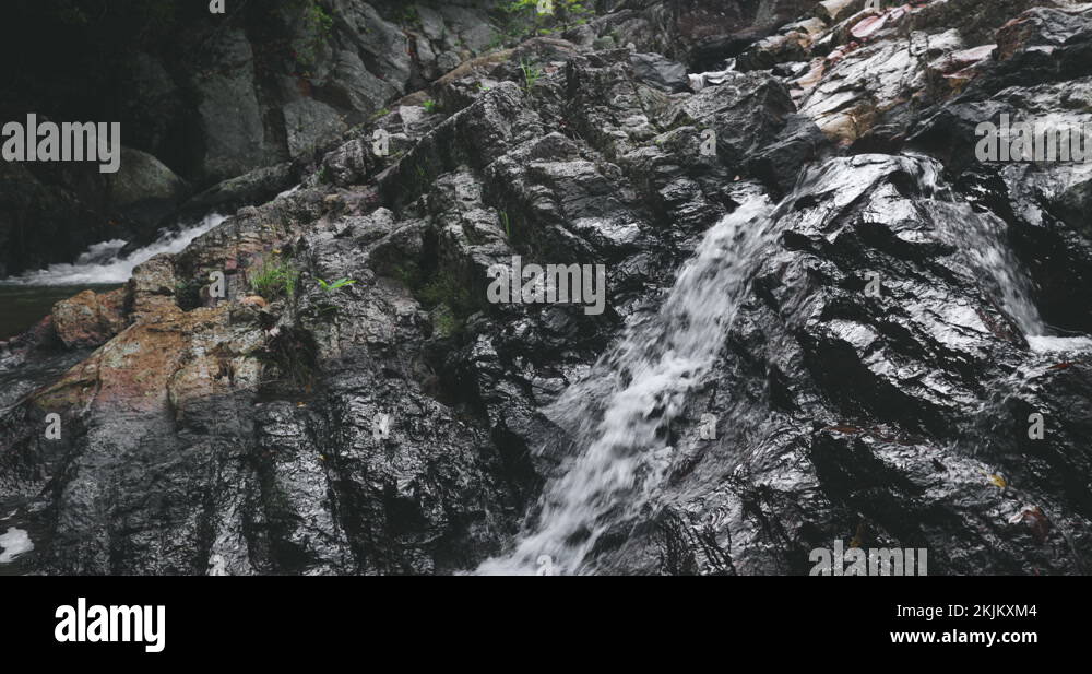 Cliff waterfall closeup: Thailand's landmark. Tiny water flow on rocky ...
