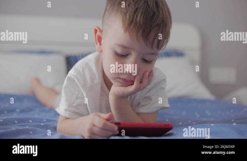 Cute little boy preschool child using a phone or digital tablet ...