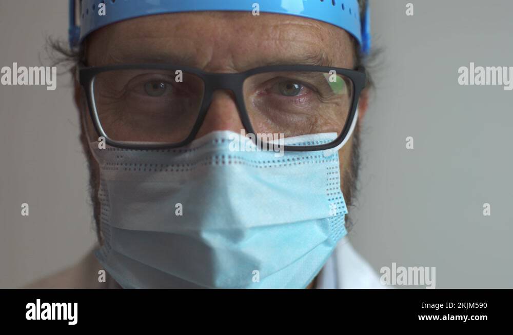 Tired handsome male doctor taking off the surgical face mask Stock ...