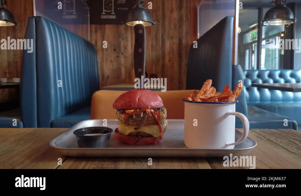 A crispy jackfruit burger on a beetroot brioche bun inside a restaurant ...