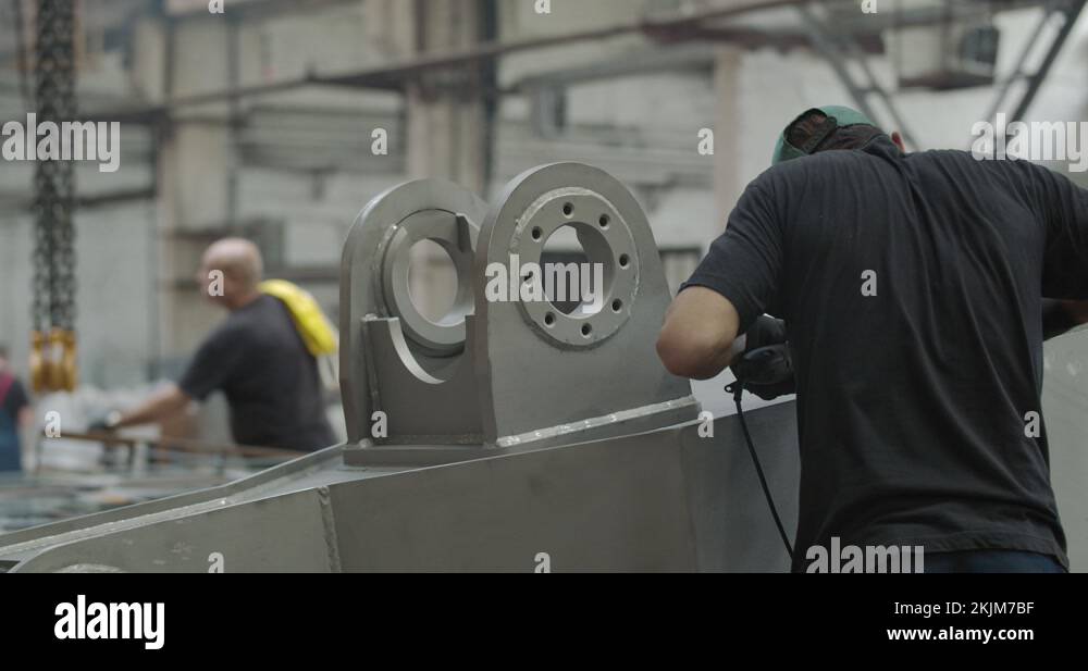 Factory workers at work, polishing the parts of a mud gun machine, 4k ...