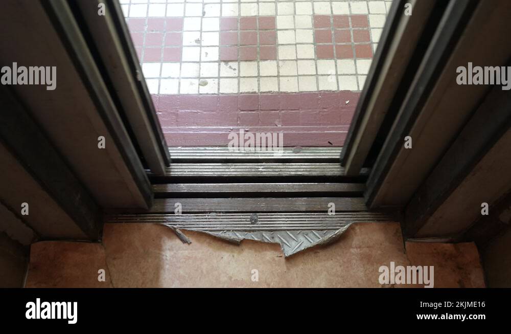 The metal elevator doors close automatically. Badly worn interior of an ...
