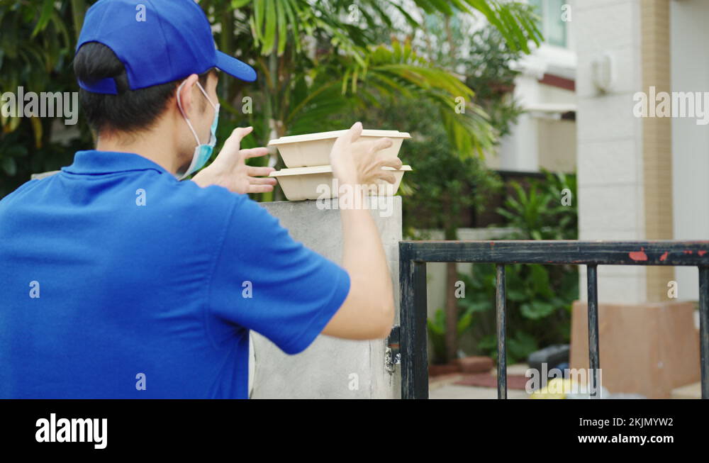 Young delivery man wear face mask handling food box for send to ...