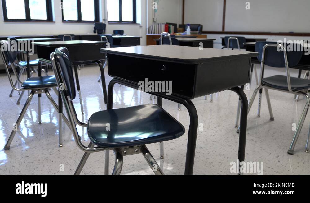 Motion to the right showing empty school classroom with chairs under ...