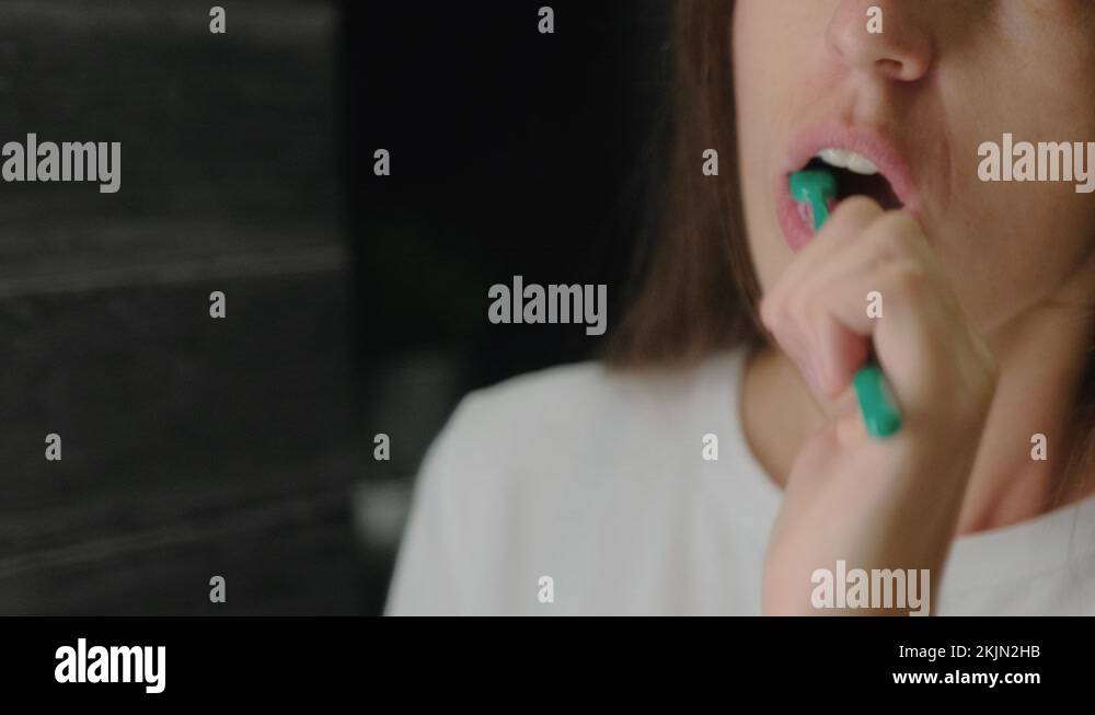 Young girl brushing teeth with green brush in modern bathroo. Personal ...