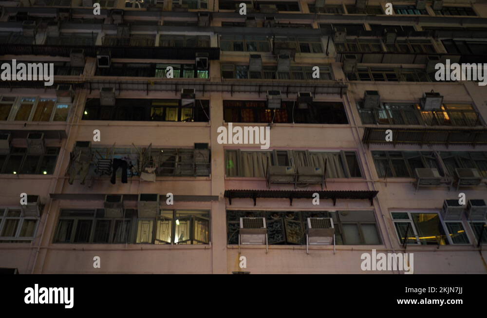 Low angle of Hong Kong overcrowded old apartment building at night view ...