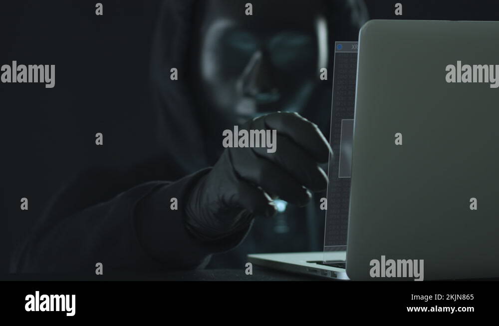 Hacker wearing black mask pulls VIRUS tab from a laptop. Hacking ...
