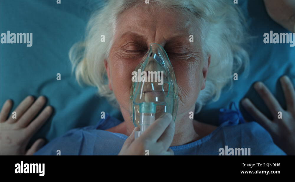 Paramedics Checking Pulse And Putting Oxygen Inhalation Mask On Old