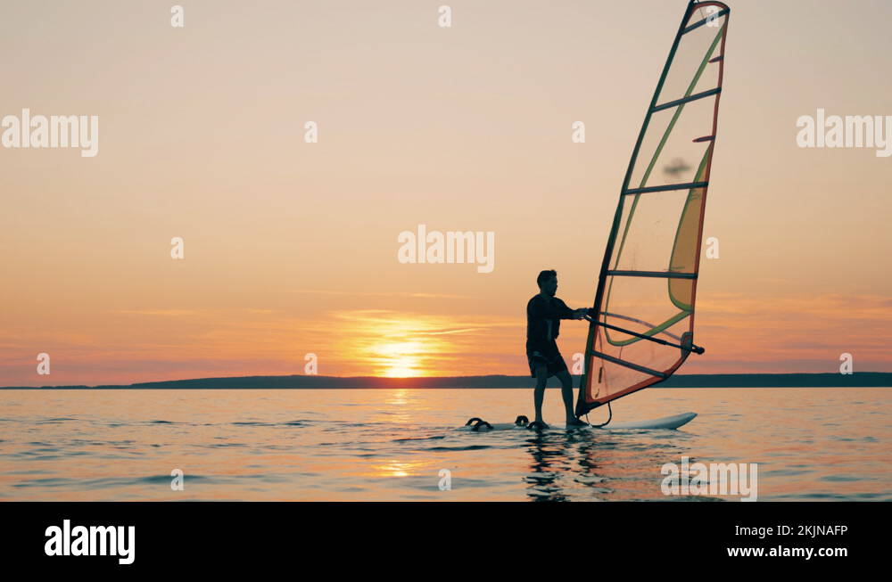 A man is managing a sail of a windsurf board while floating Stock Video ...