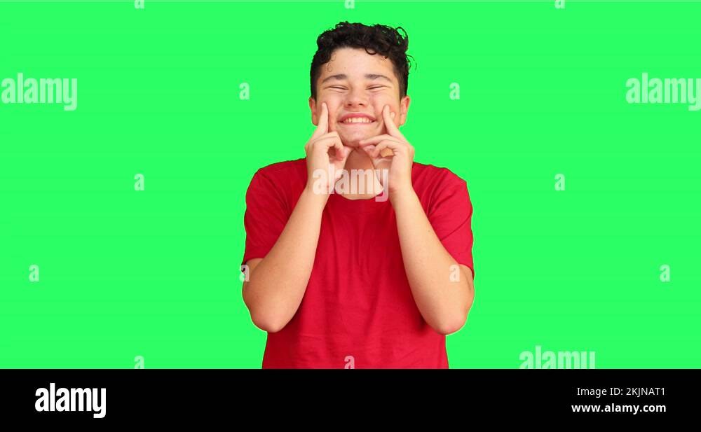 Young boy making silly faces at green screen background Stock Video ...
