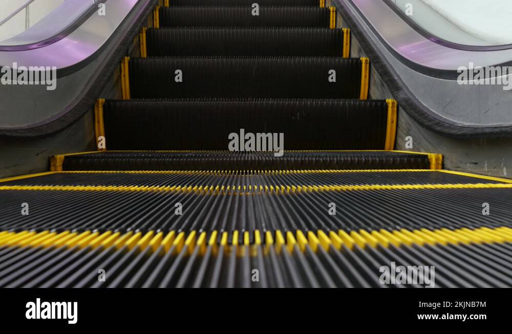 Low angle looped perspective view of modern escalator stairs. Automated ...