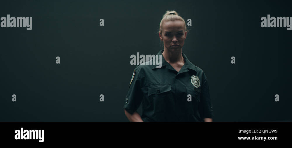 FIXED Portrait of Caucasian female police officer posing against dark ...