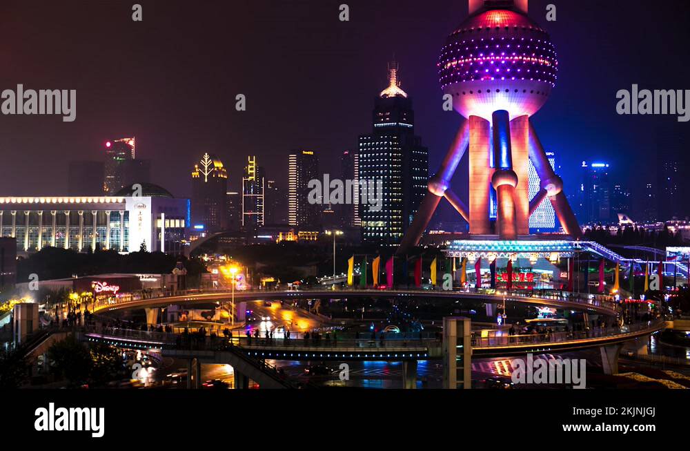 Shanghai - Night view of roundabout traffic skywalk by glowing tower ...