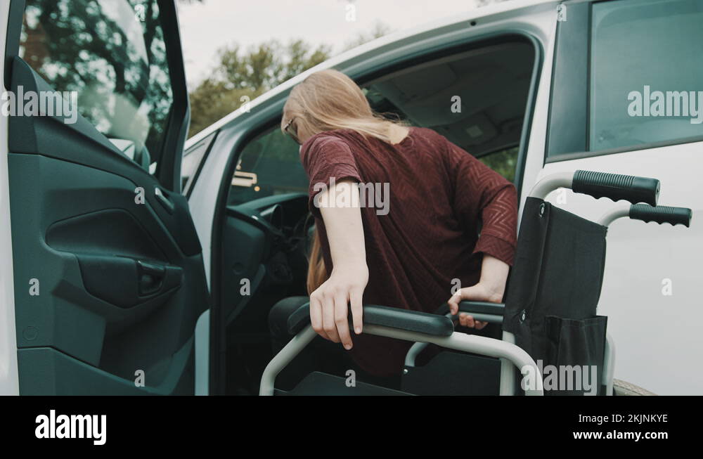 Young disabled person getting out from the car in her wheelchair Stock ...