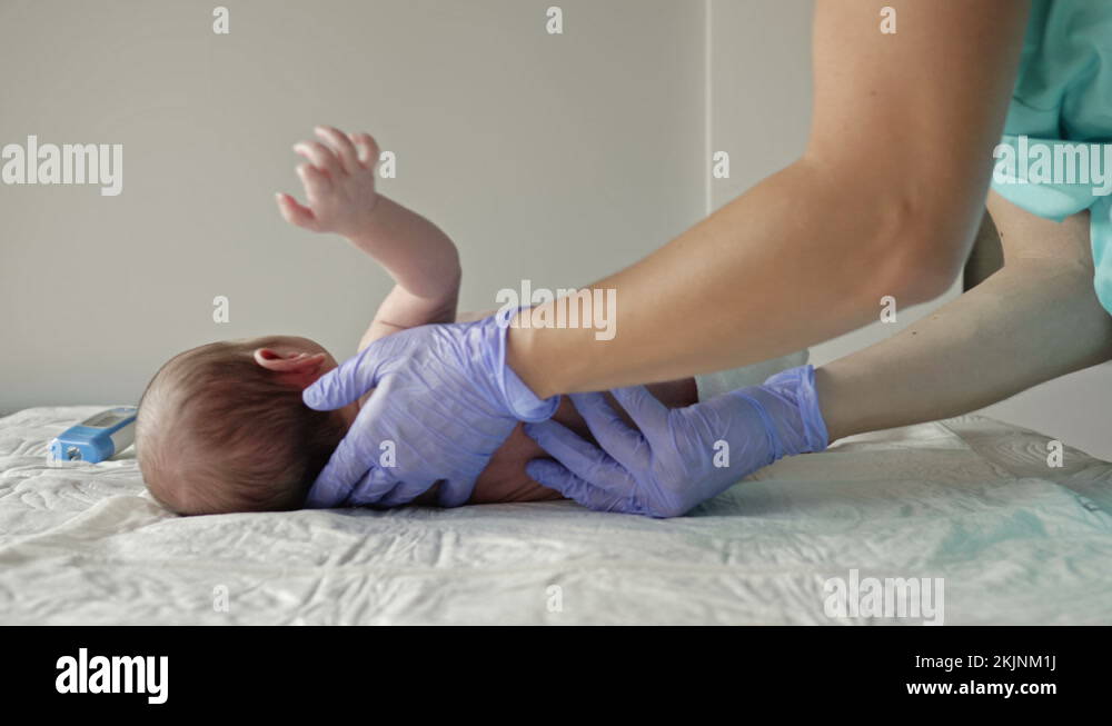 Pediatrician places the newborn on the changing table for examination ...