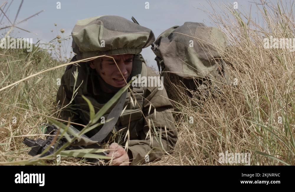 Army infantry soldier carrying his wounded fellow warrior, while ...