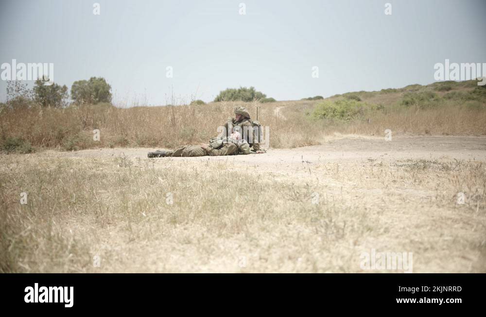 Army infantry soldier carrying his wounded fellow warrior, while ...