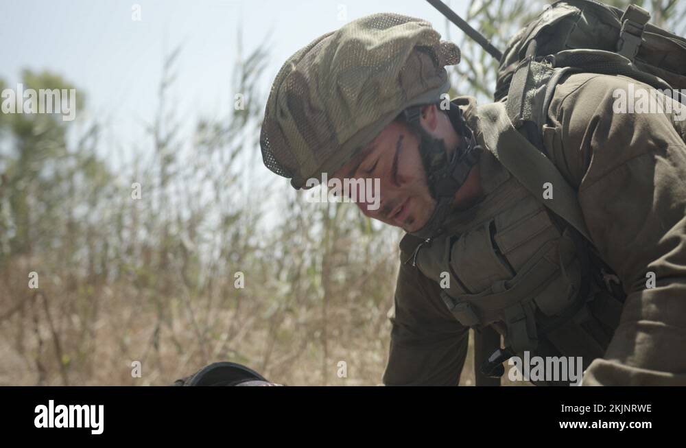 Army infantry soldier carrying his wounded fellow warrior, while ...