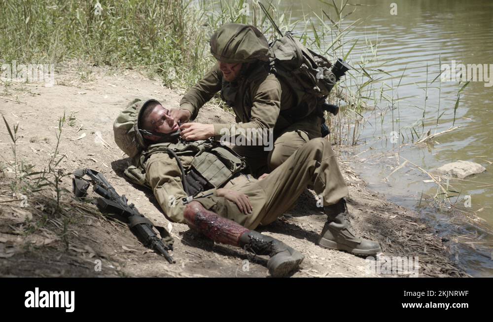Army infantry soldier carrying his wounded fellow warrior, while ...
