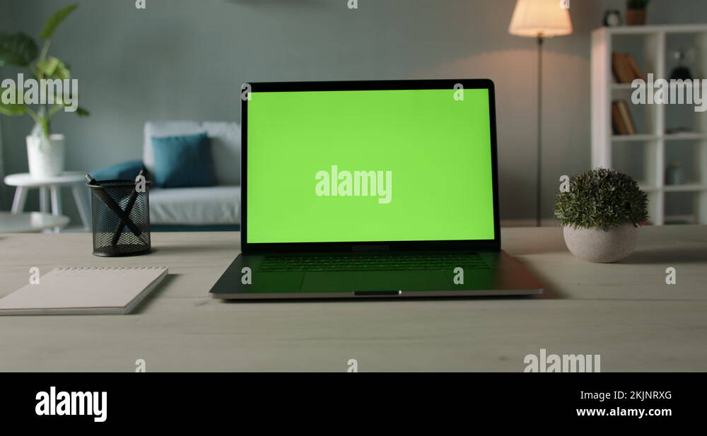 Modern laptop with mock up chroma key green screen on table of living ...