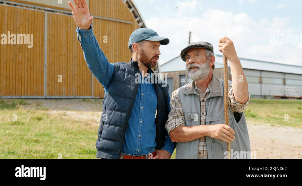 Caucasian young man standing outdoor with old gray-haired father in ...