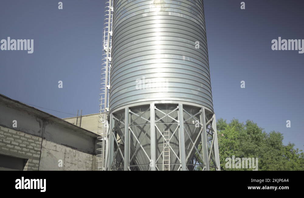 Camera goes down along enormous stainless steel cement storage silo ...
